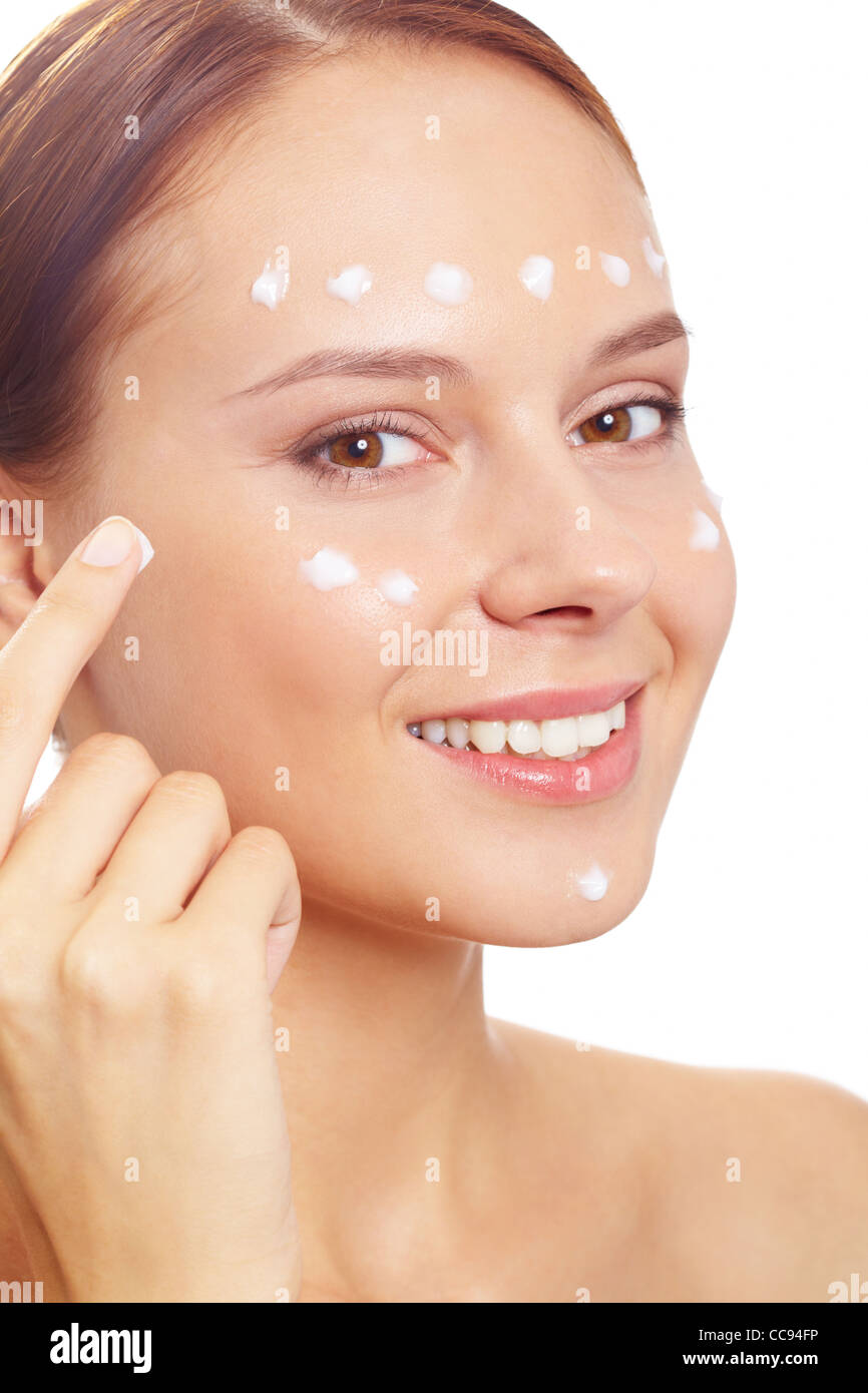 Fresh woman applying hydrating cream onto her face Stock Photo - Alamy