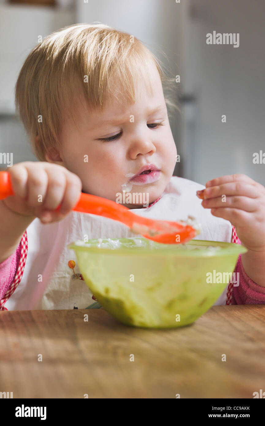 Baby Girl Eating from Bowl Stock Photo - Alamy