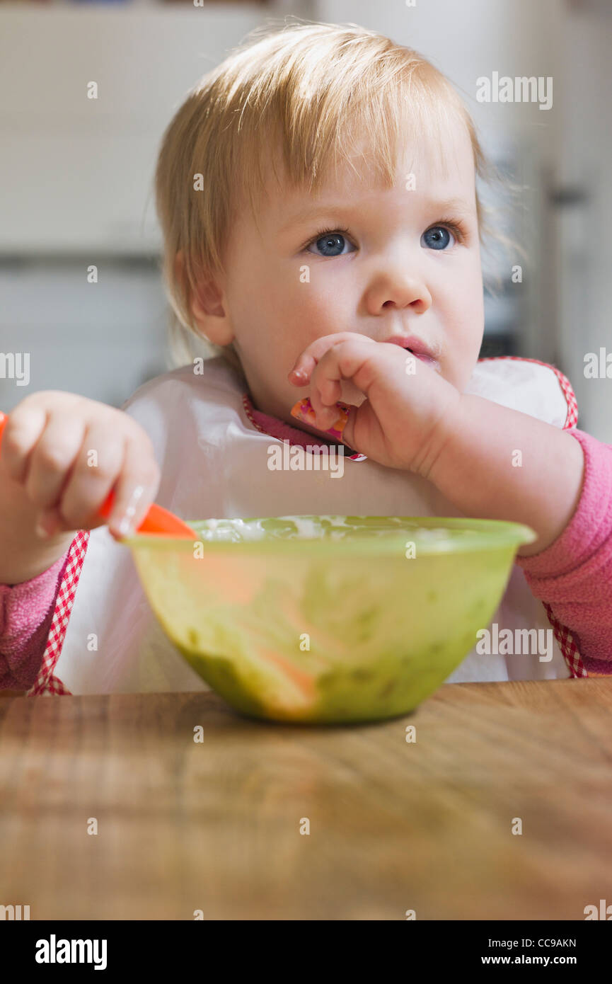 Baby Girl Eating from Bowl Stock Photo - Alamy