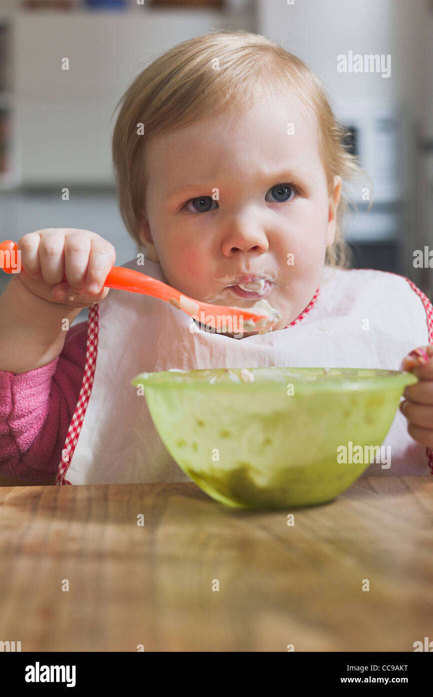 Baby Girl Eating from Bowl Stock Photo - Alamy