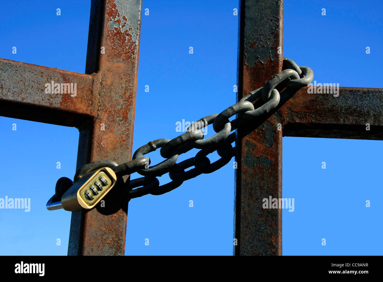 Iron chain with safety number lock closing a rusty gate Stock Photo - Alamy