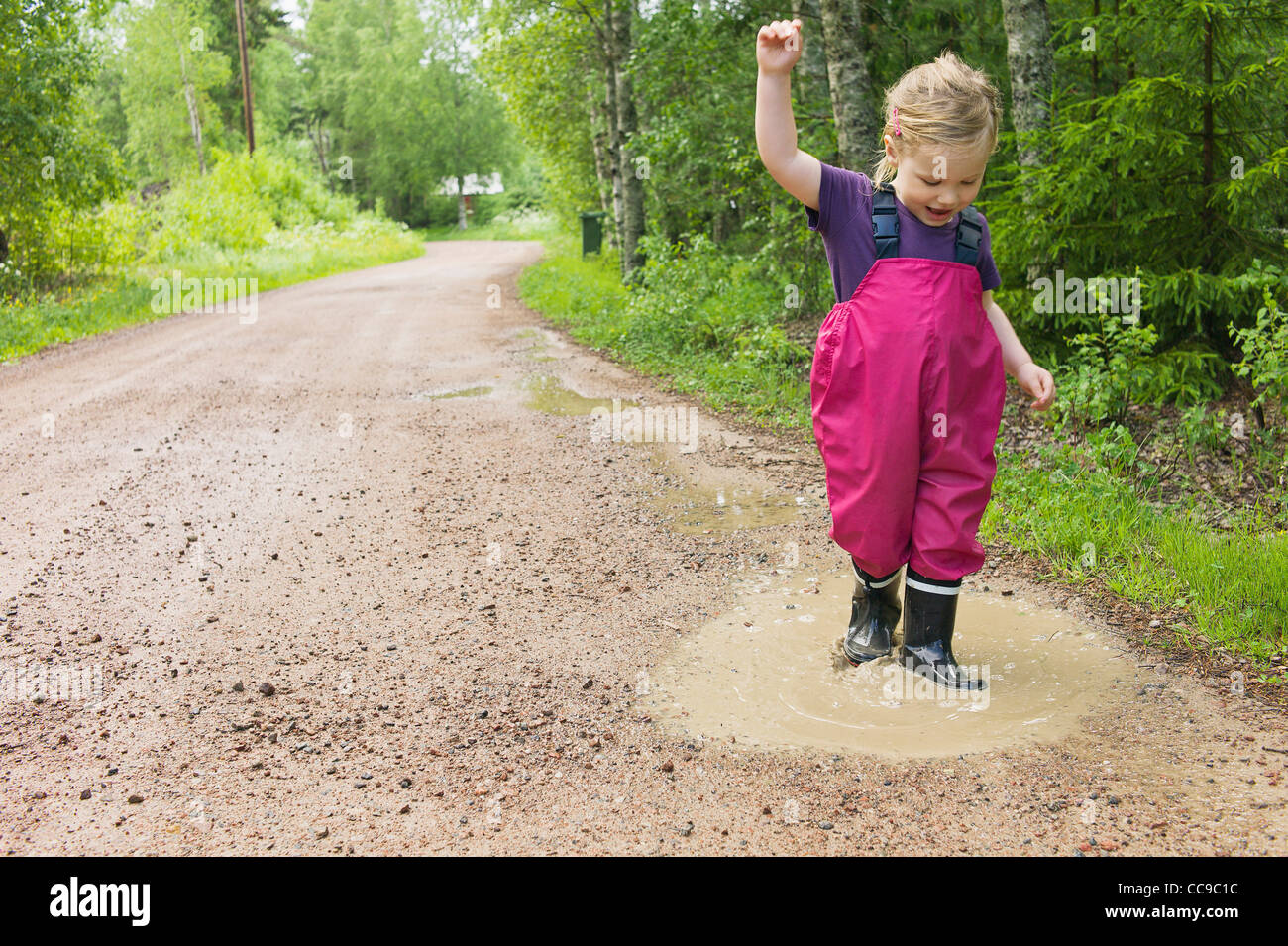 Young Girl Playing in Puddle, Sweden Stock Photo - Alamy