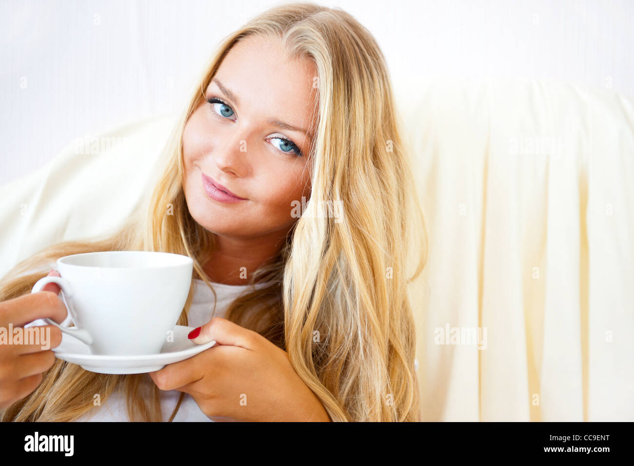 Young woman at home sipping tea or coffee from a cup Stock Photo - Alamy