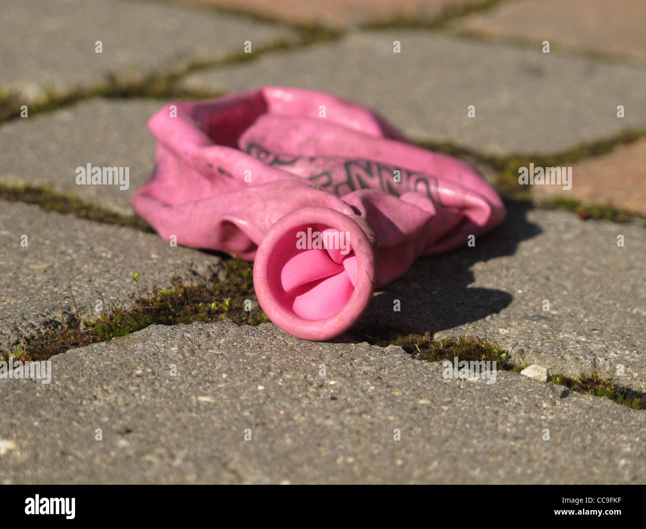 close up detail of one burst pink balloon on floor ground Stock Photo ...