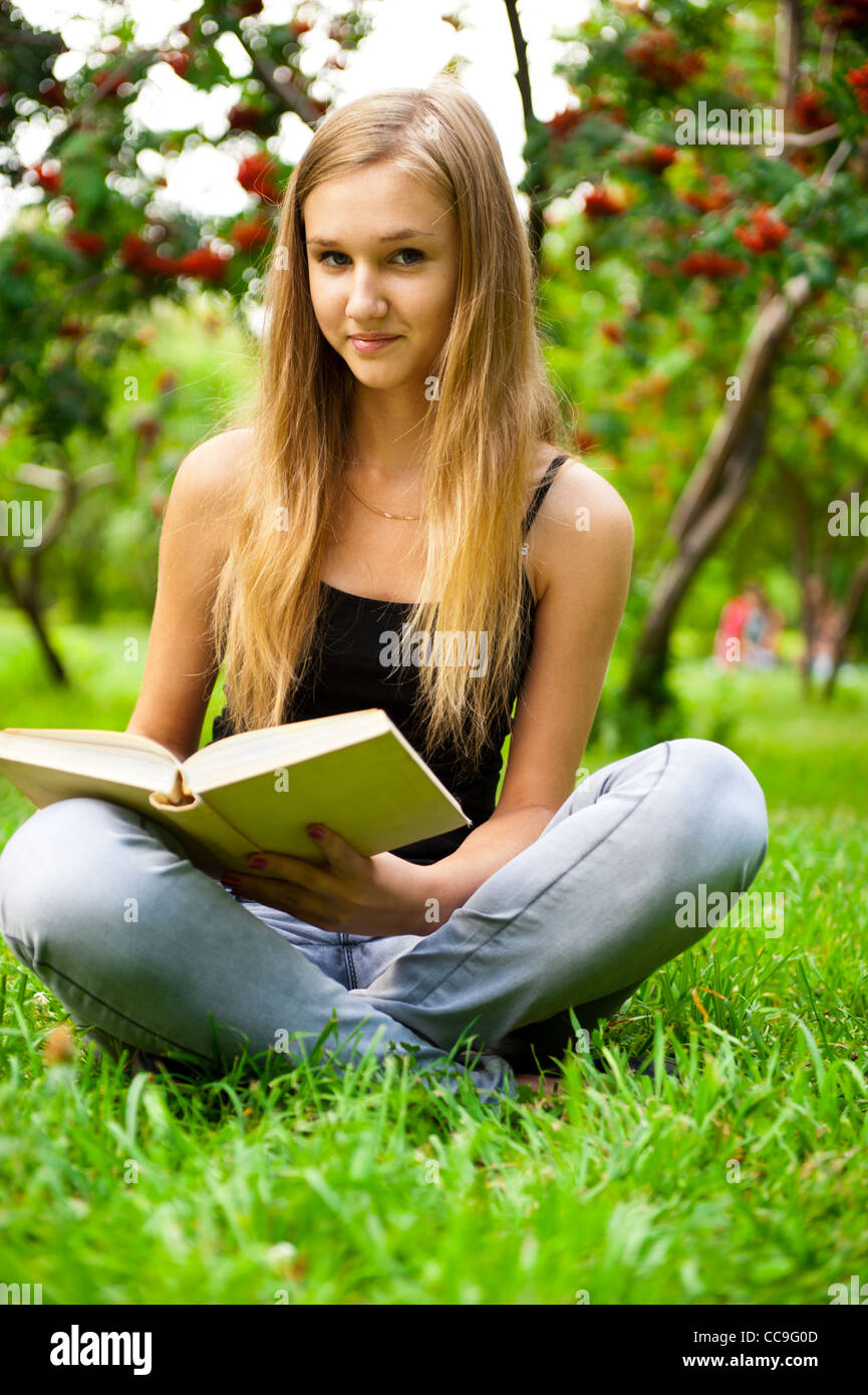 Beautiful female student outdoors with a book at campus park Stock ...