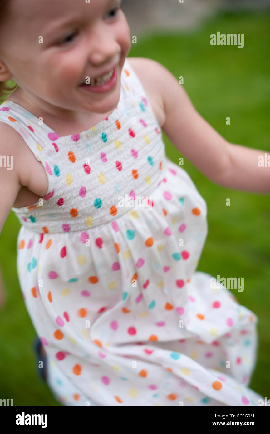 Girl running in a spotty dress Stock Photo - Alamy