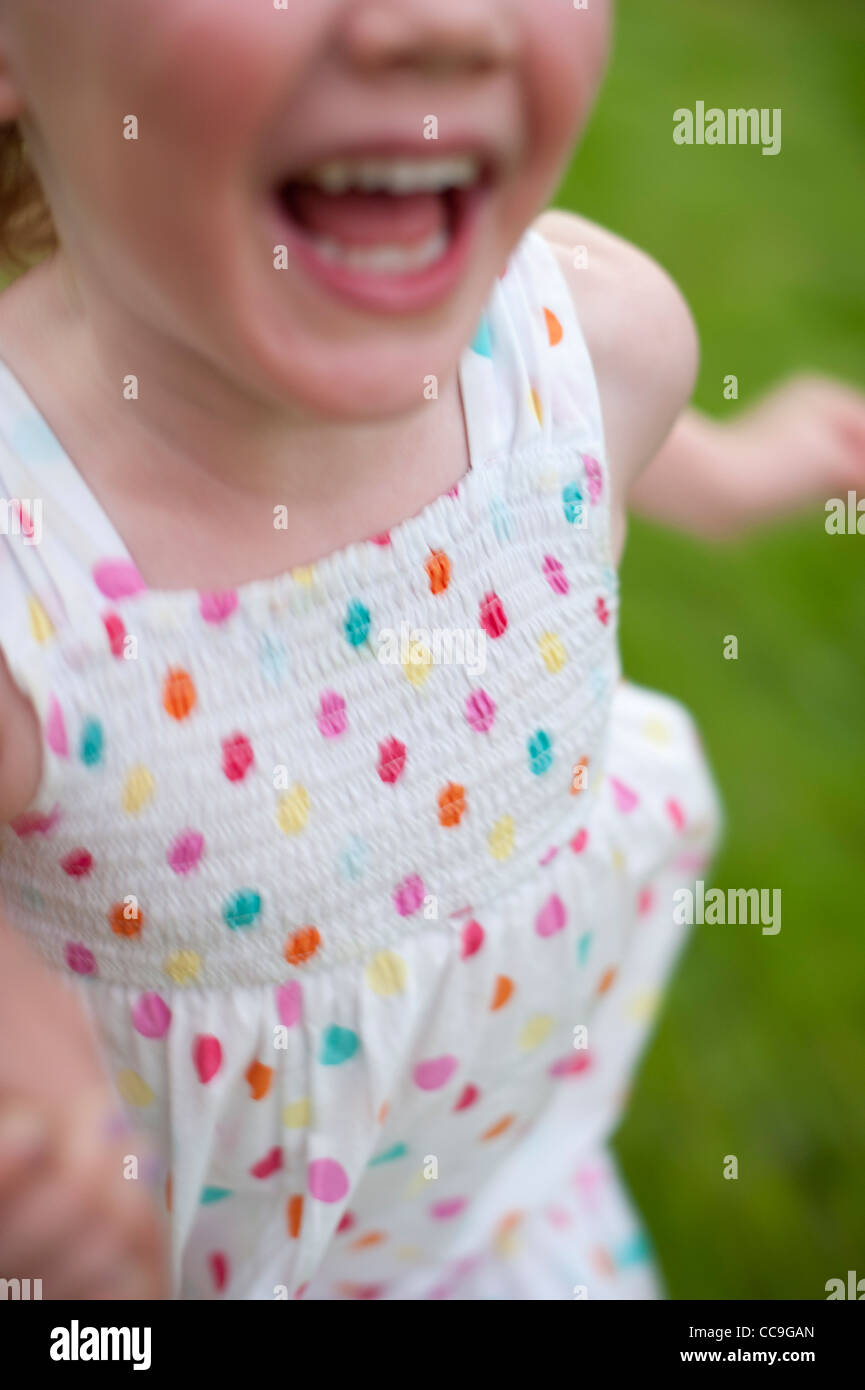 Girl running in a spotty dress Stock Photo - Alamy