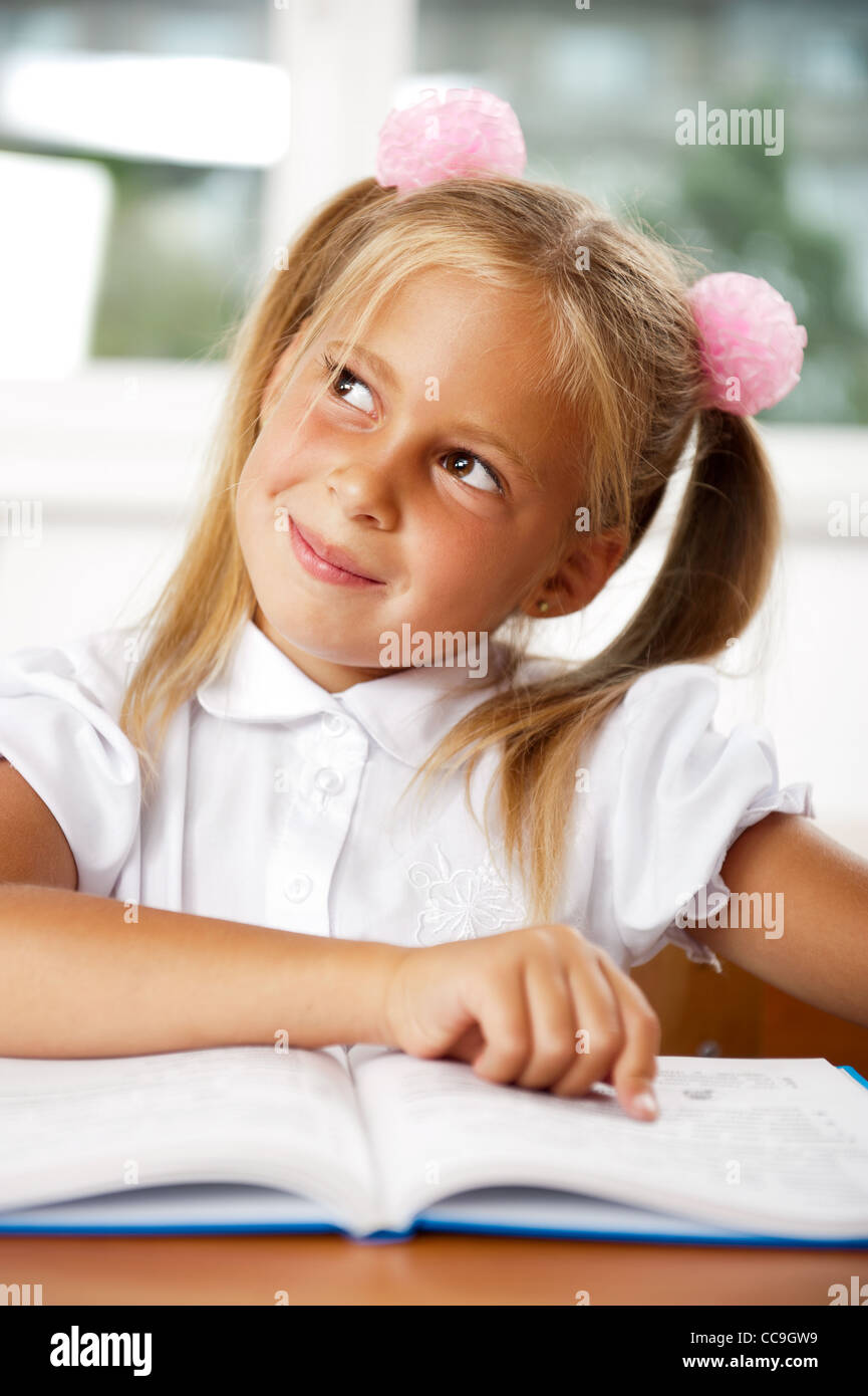 Image of smart child reading interesting book in classroom. Vertical ...