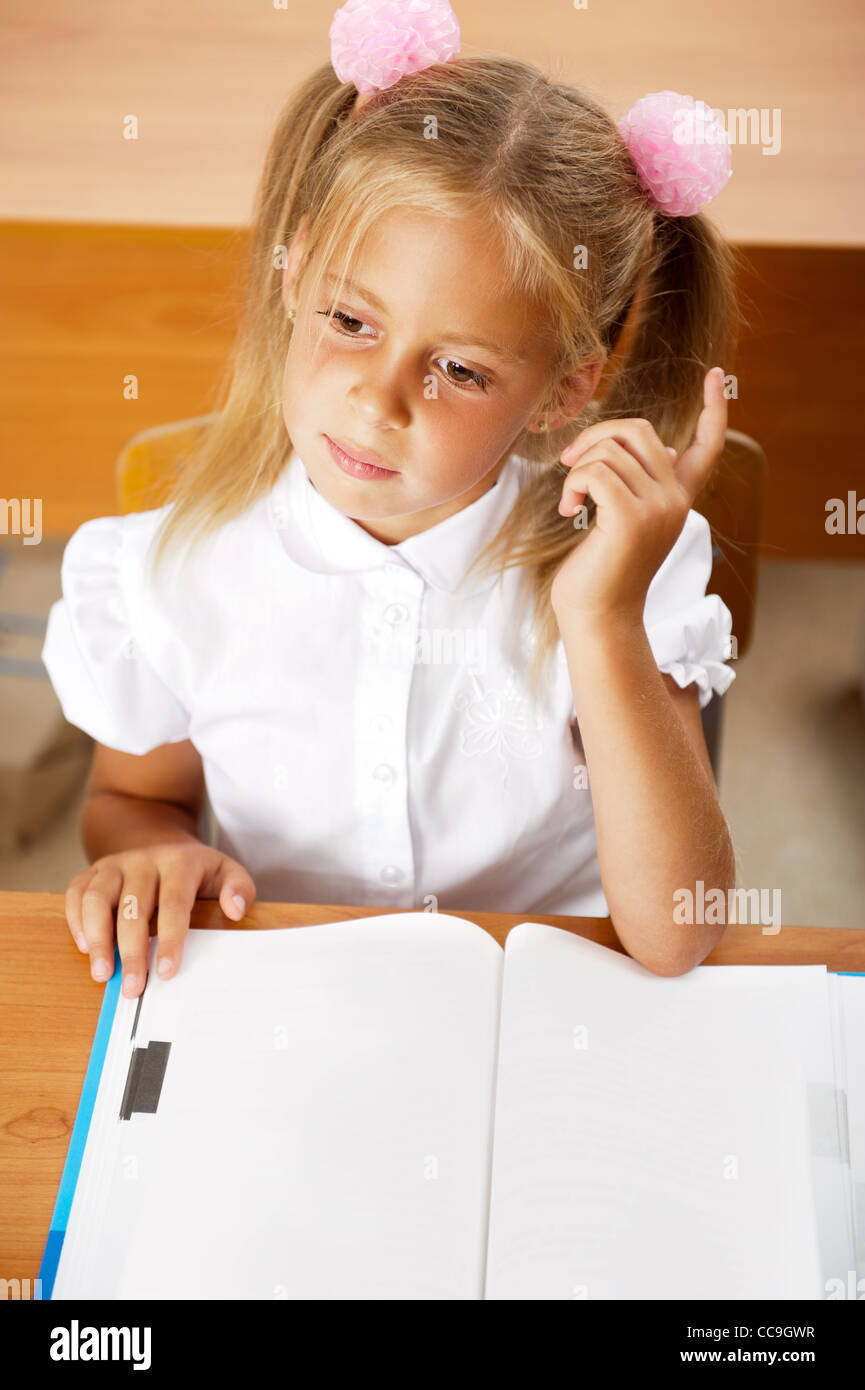Image of smart child reading interesting book in classroom. Vertical ...
