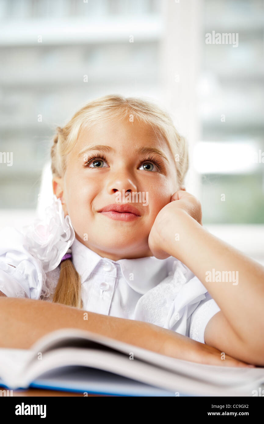 Image of smart child reading interesting book in classroom. Vertical ...