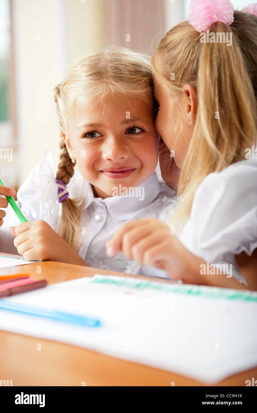 Two little girls gossip in classroom Stock Photo - Alamy
