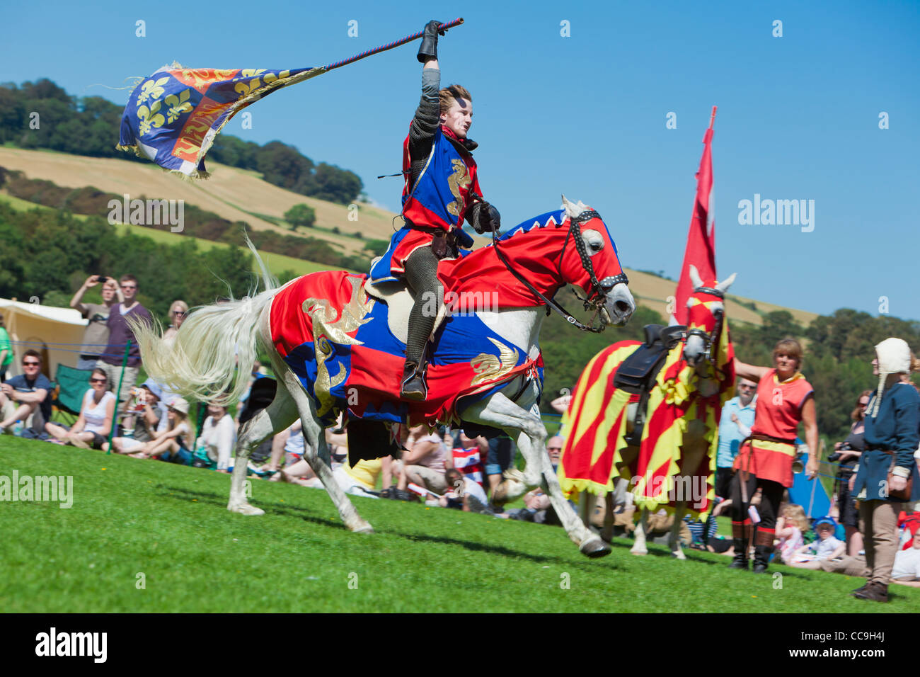 Knight on horse back with colourful flag Stock Photo - Alamy