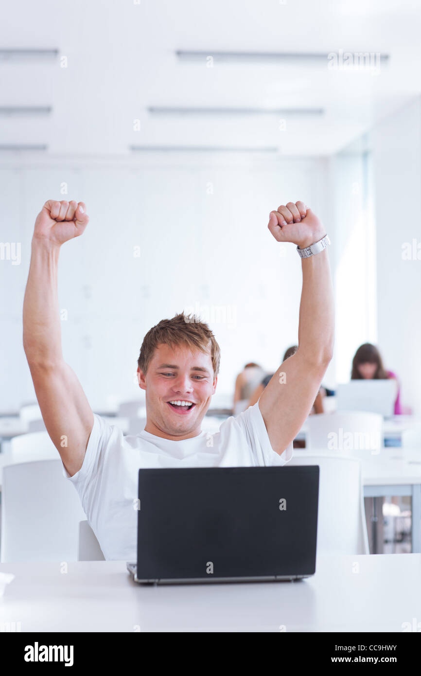 happy handsome college student with laptop computer in university ...