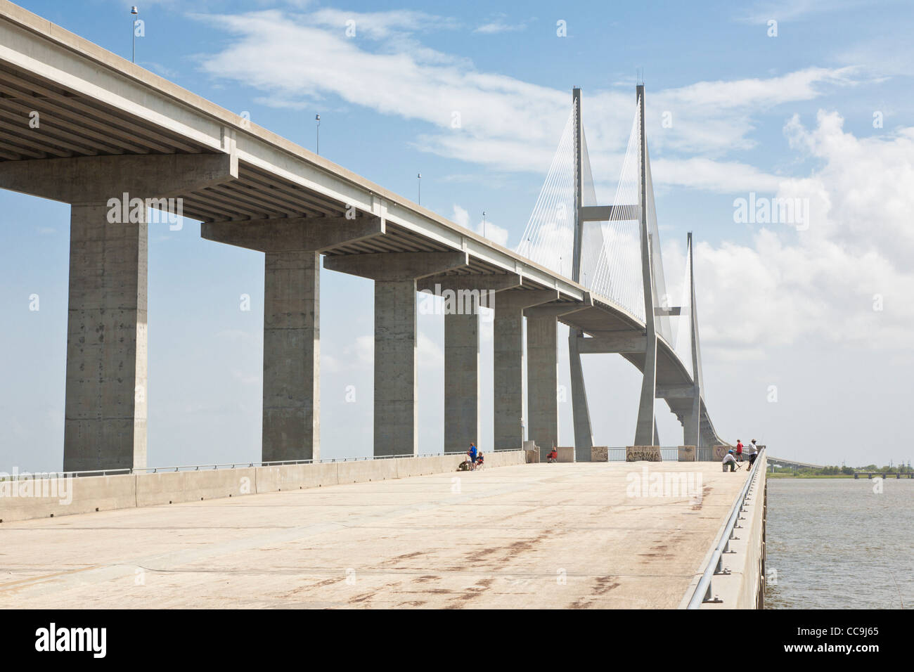 People fishing on pier next to the Sidney Lanier Bridge over the ...
