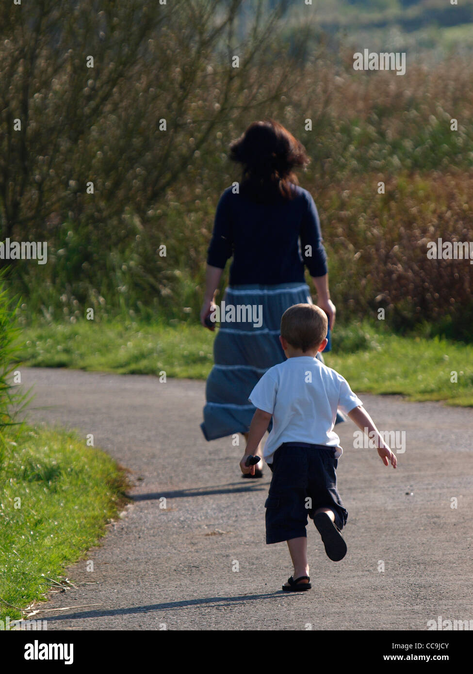 Small child running after his mother, UK Stock Photo - Alamy