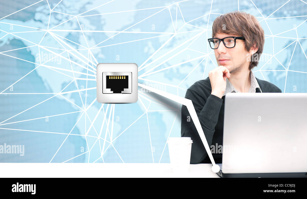 Portrait of happy young business man using his laptop. World map on the ...