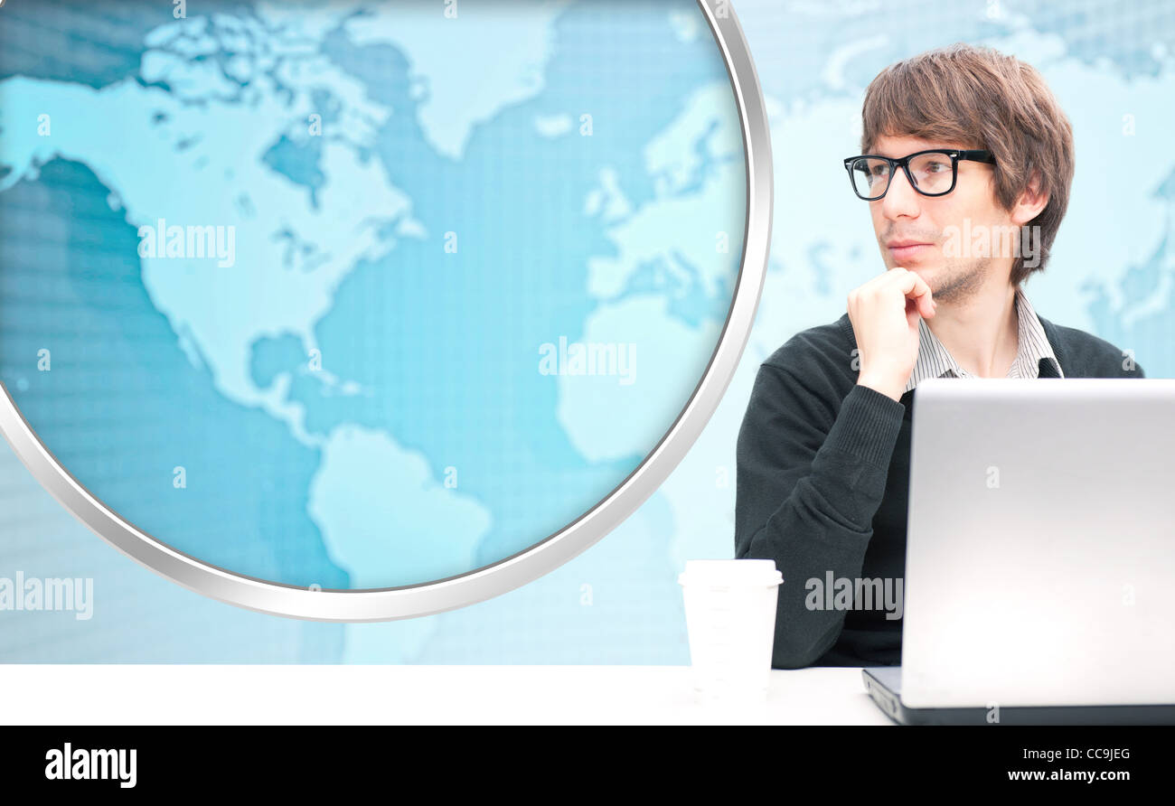 Portrait of happy young business man using his laptop. World map on the ...