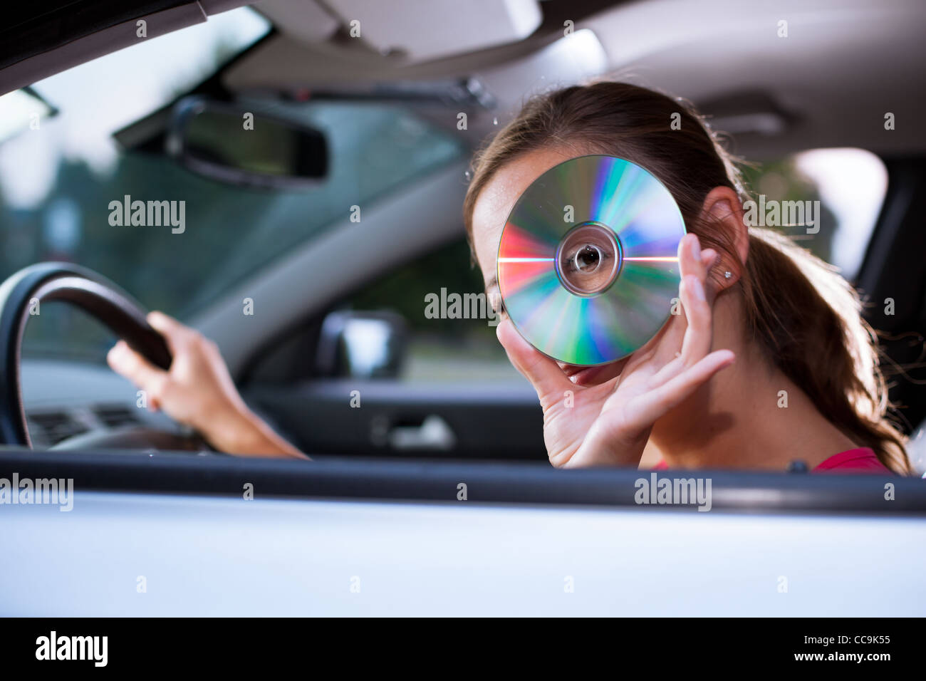 Young female driver playing music in the car (changing CDs Stock Photo ...