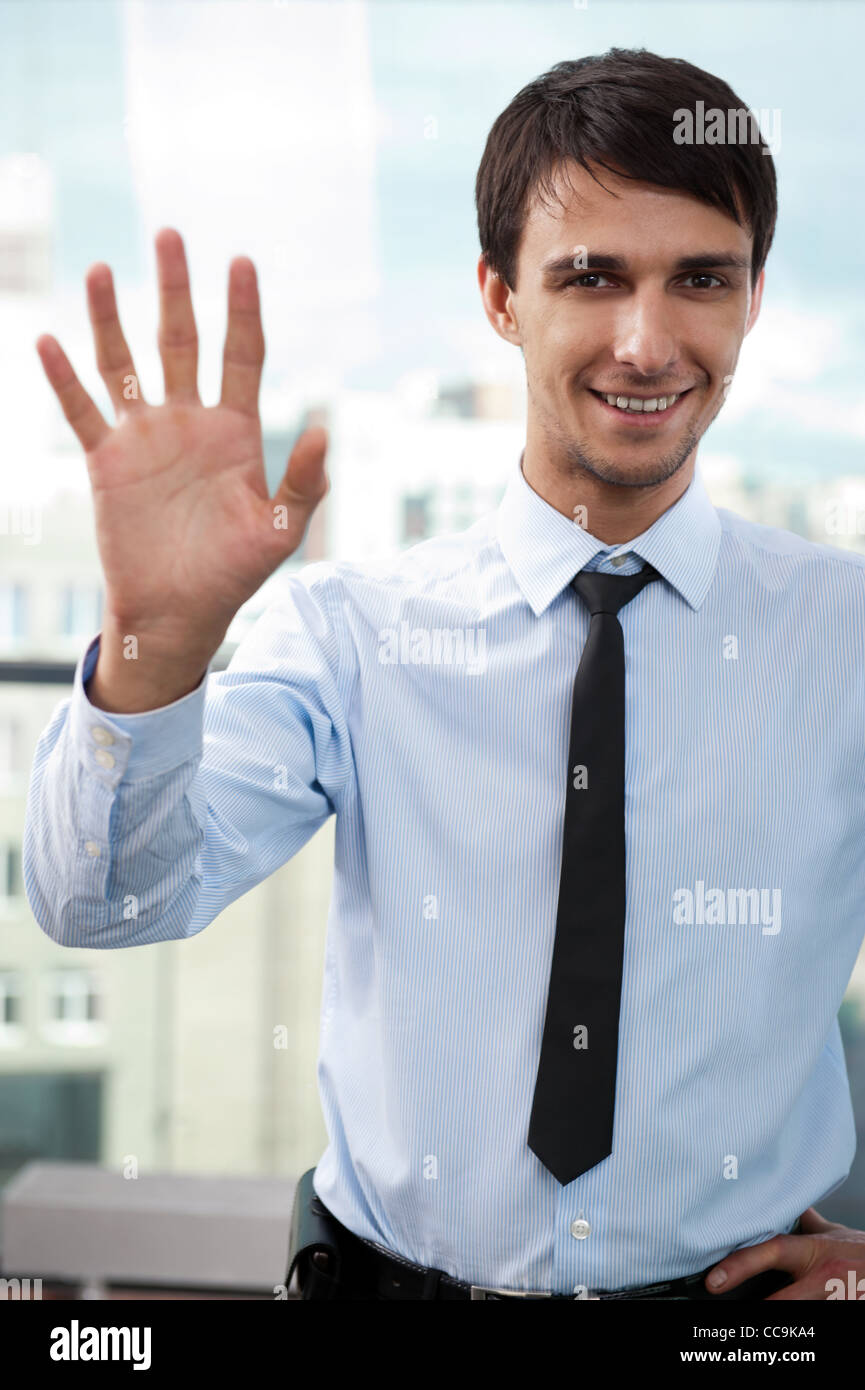 Portrait of young relaxed business man waving hand to camera Stock ...