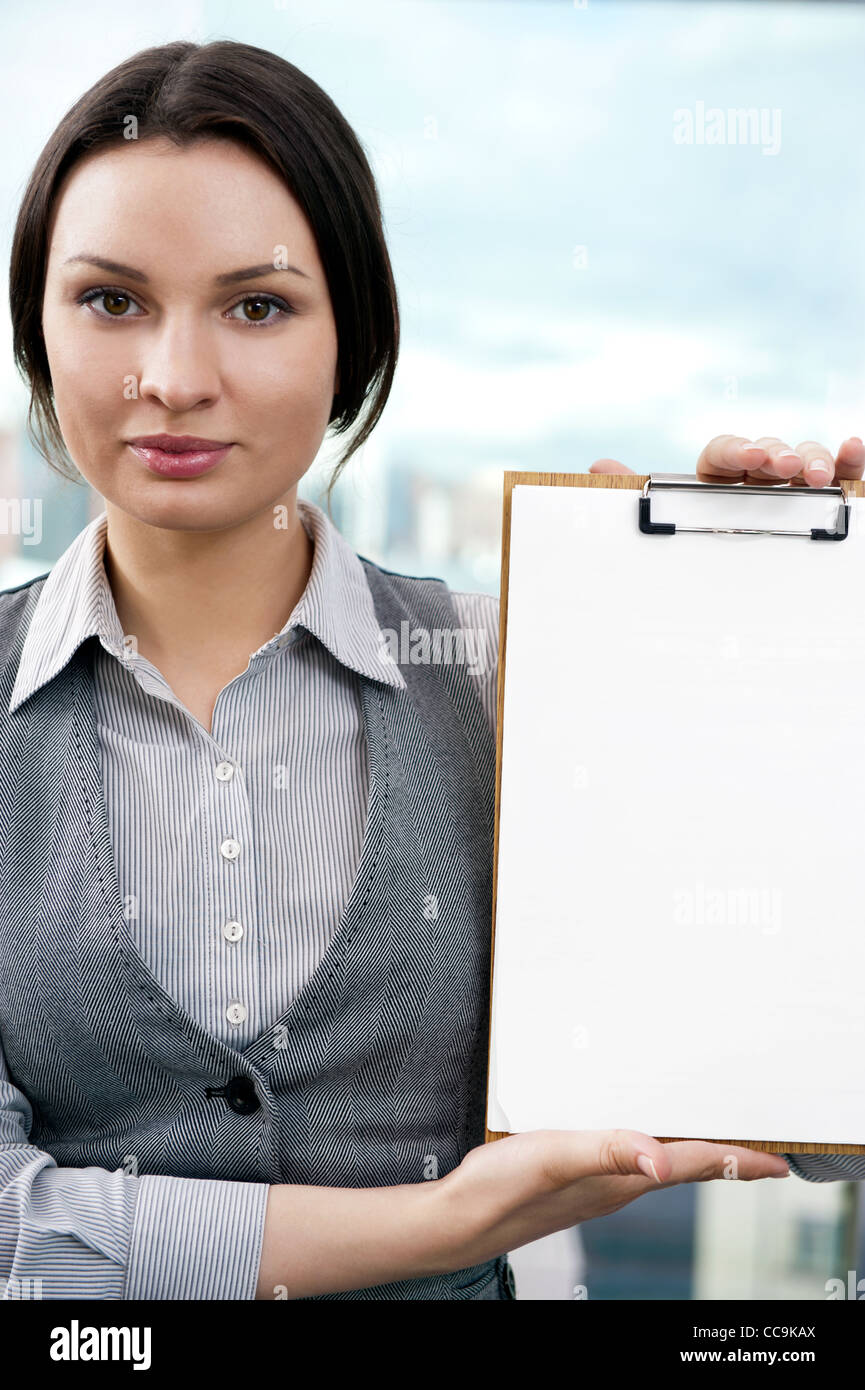 Portrait of business woman holding blank reports and looking at camera ...