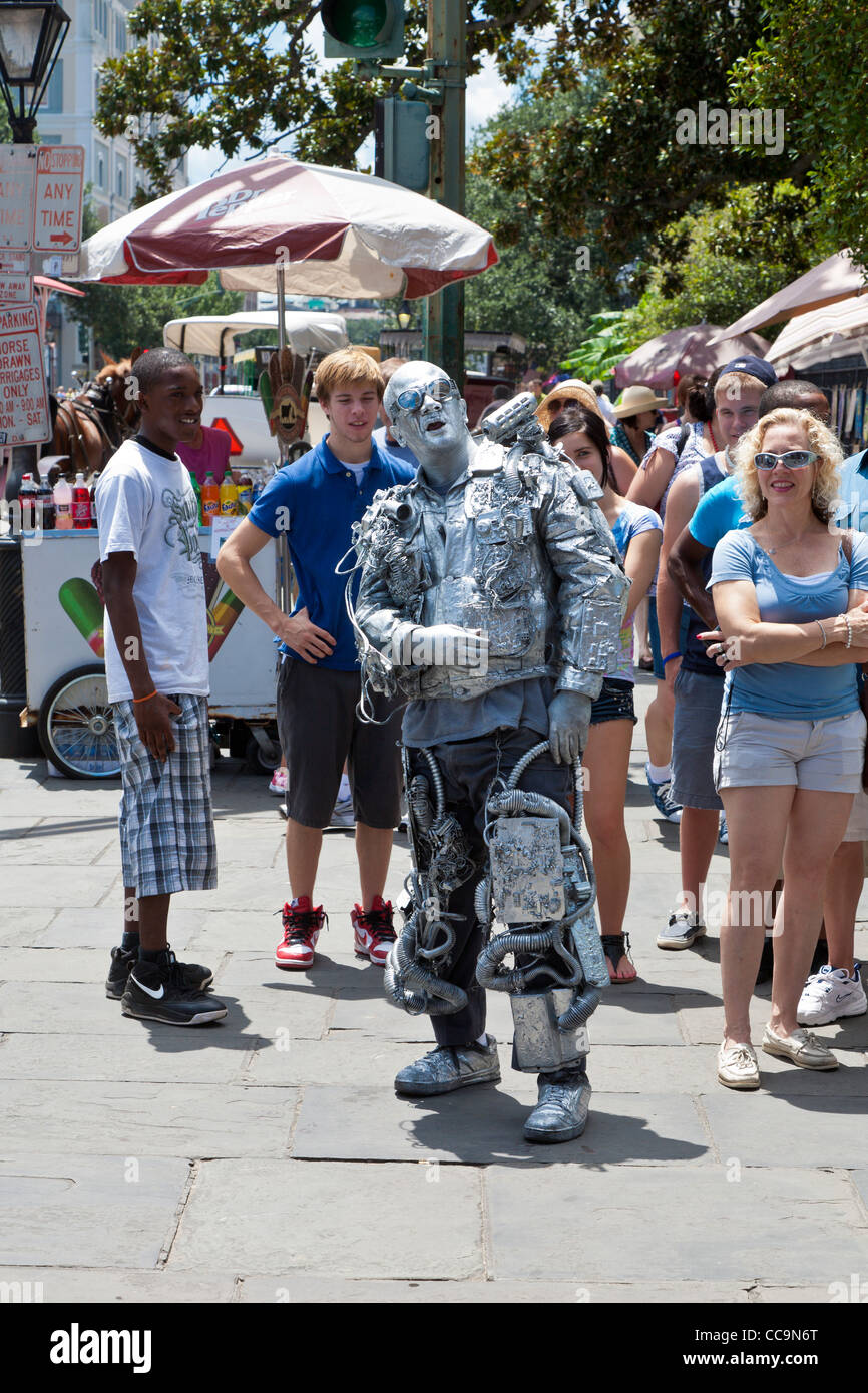 Street performer painted silver entertains tourists on the sidewalk in ...