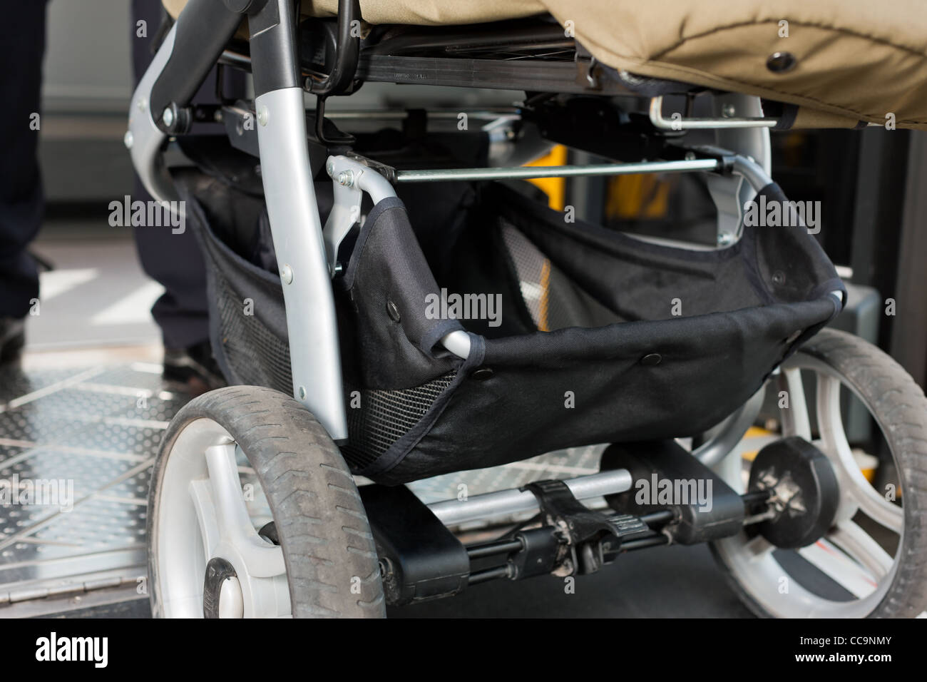 Young woman with a stroller getting into a bus on the bus station, only ...