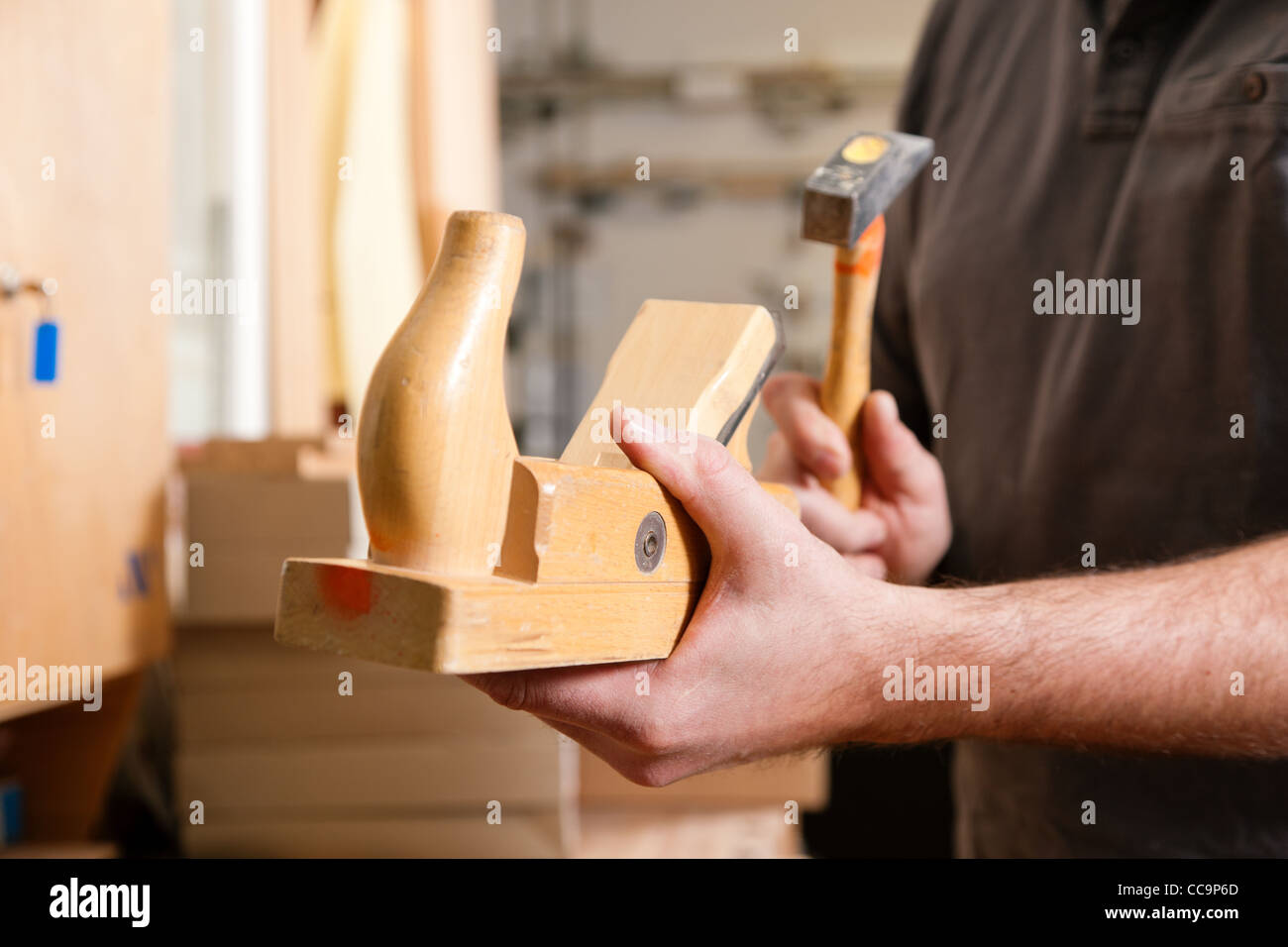Carpenter working with a planer in his workshop, close up on the tool ...