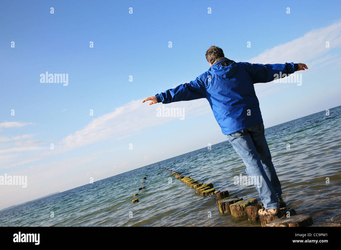 Man balancing over water Stock Photo - Alamy