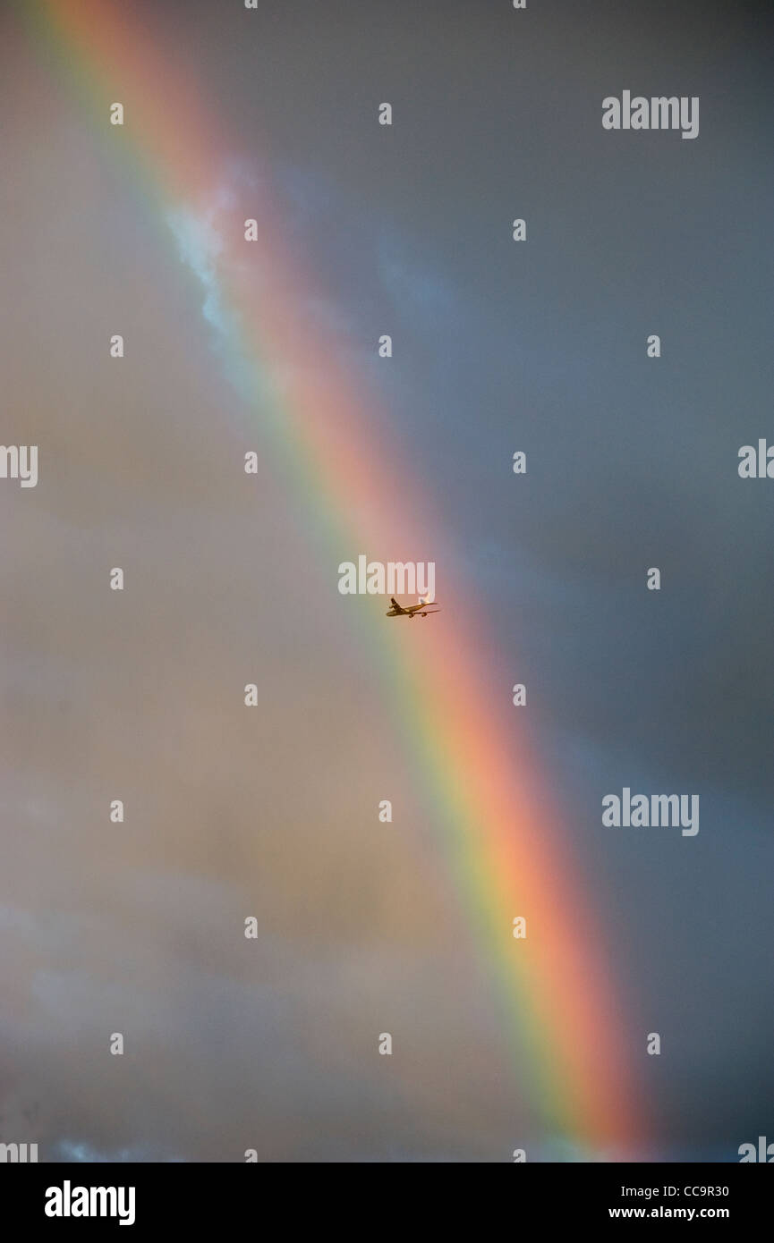 Airplane flying through rainbow Stock Photo - Alamy