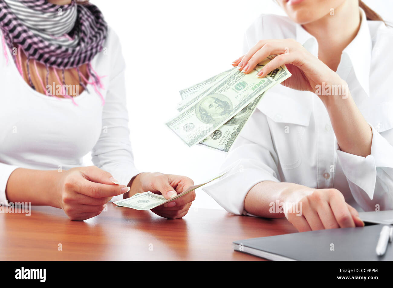 Portrait of two young pretty women in an offive environment. One gives ...