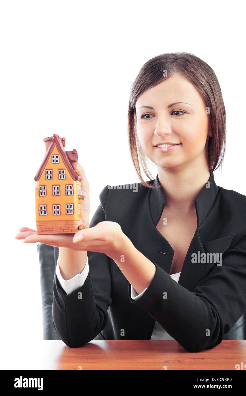 Portrait of young handsome woman holding house building in her arms ...