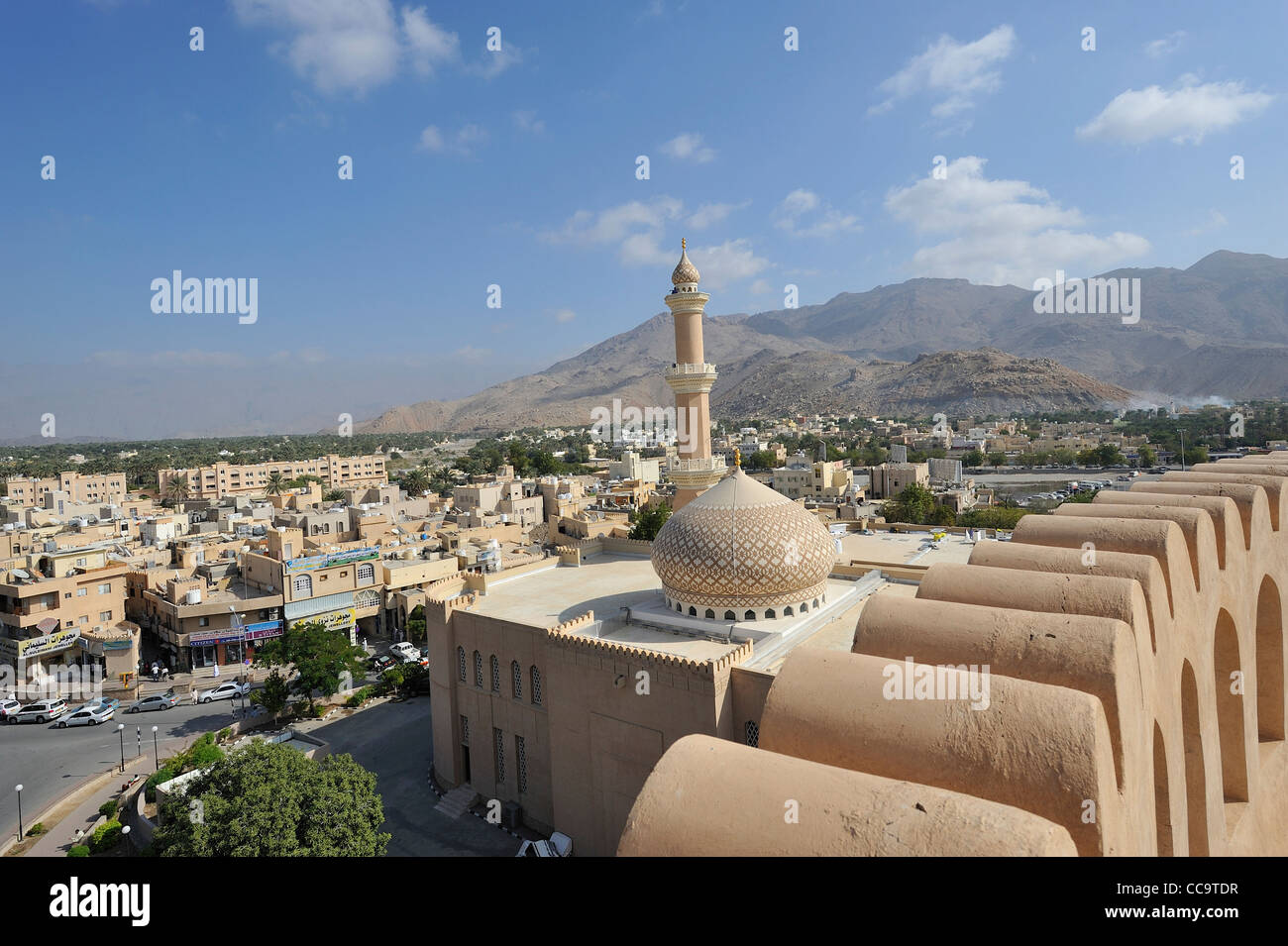 The mosque of Nizwa with stark mountains as a backdrop as it appears ...
