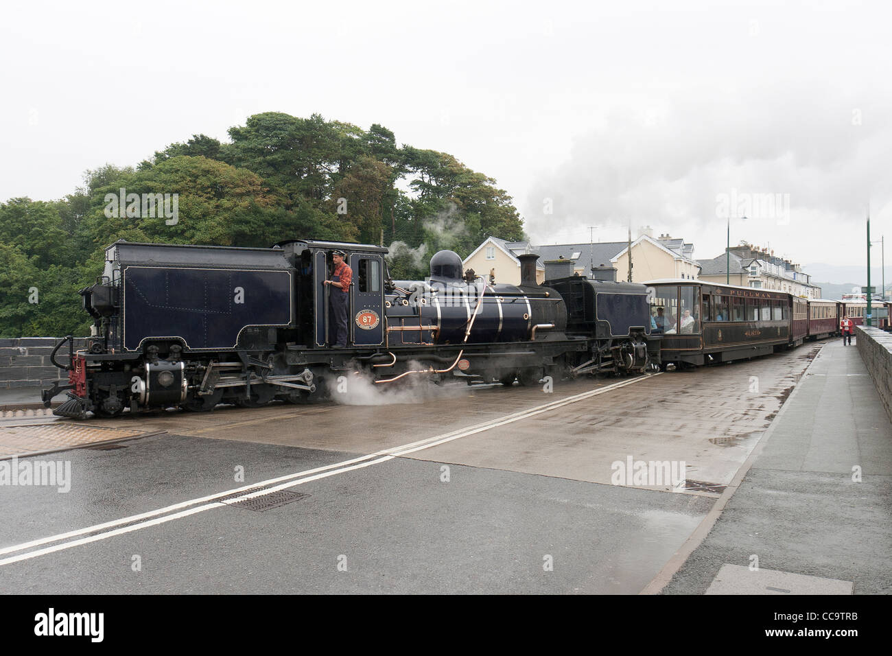 A steam locomotive with a passenger train on the Welsh Highland Line ...