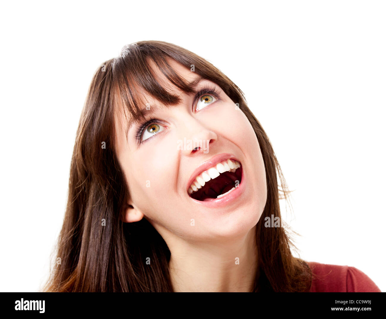 Beautiful young woman looking up and laughing, isolated on a white ...