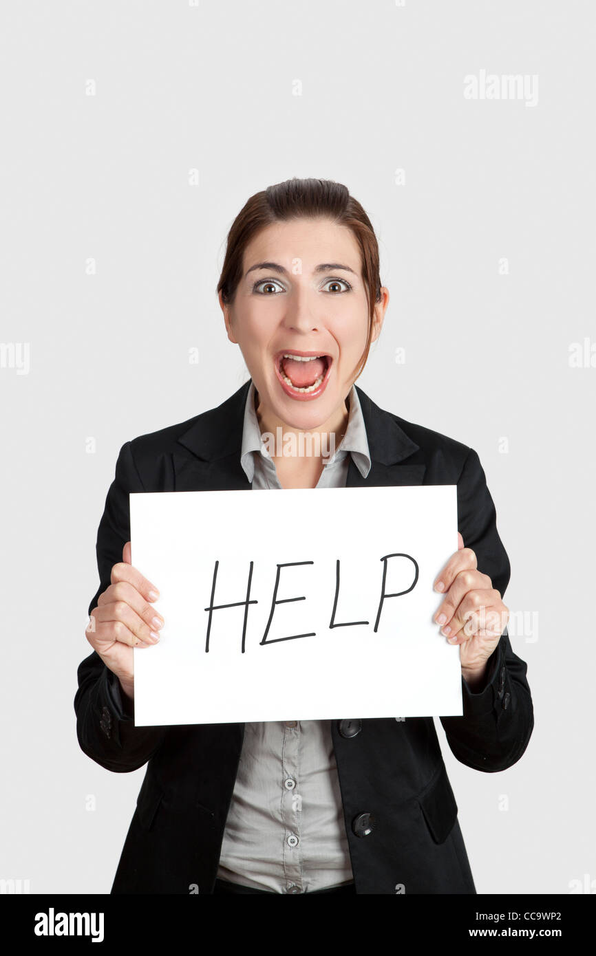 Stressed business woman imploring for help, holding a cardboard with ...