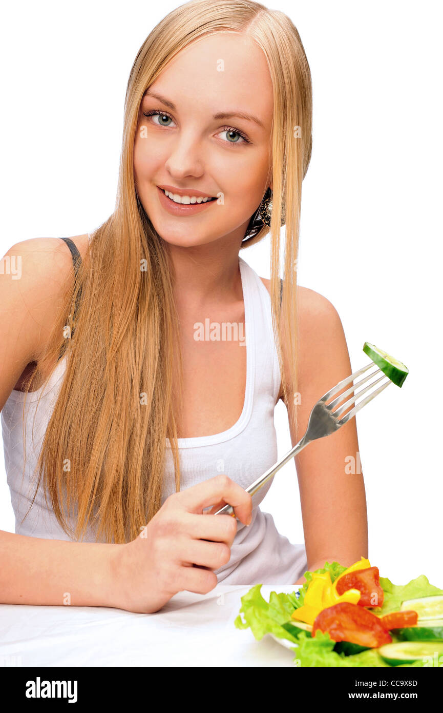 A beautiful slender girl eating healthy food isolated on white ...