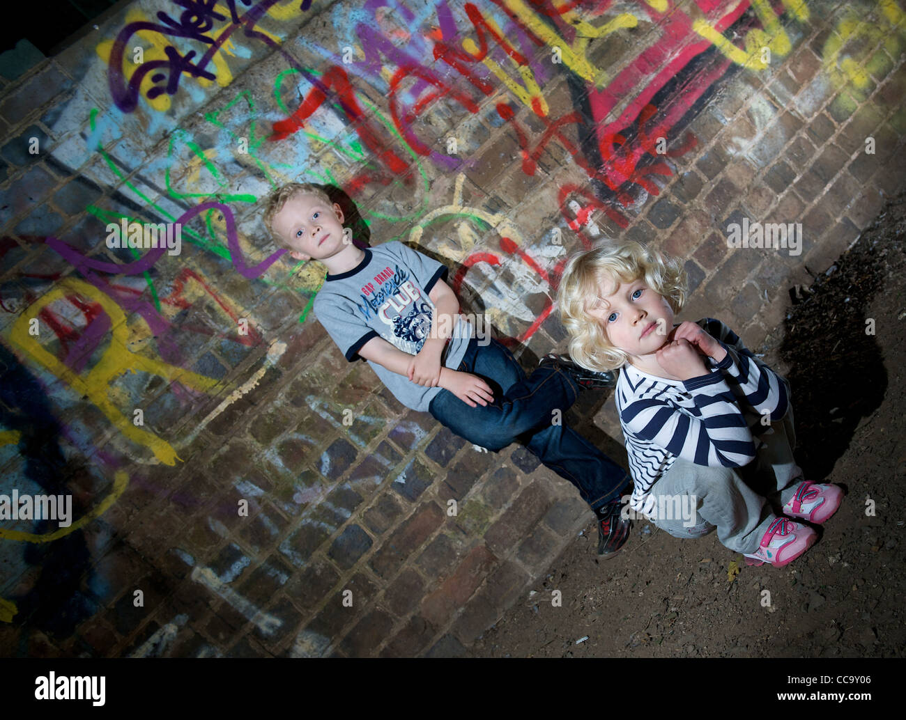 Young boy and girl pose in a graffiti daubed, urban environment Stock ...