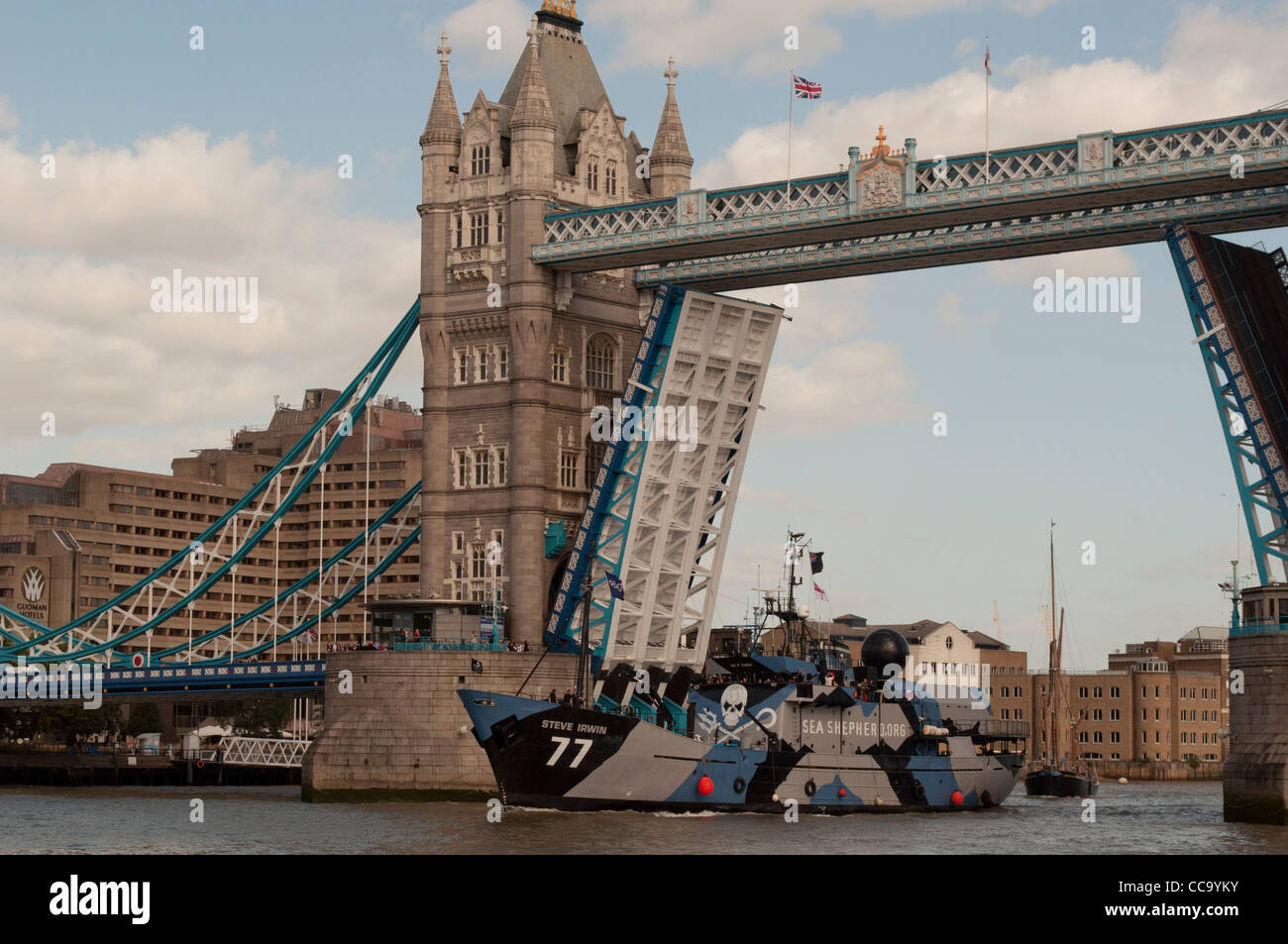 Tower bridge is open as boat sails through hi-res stock photography and ...