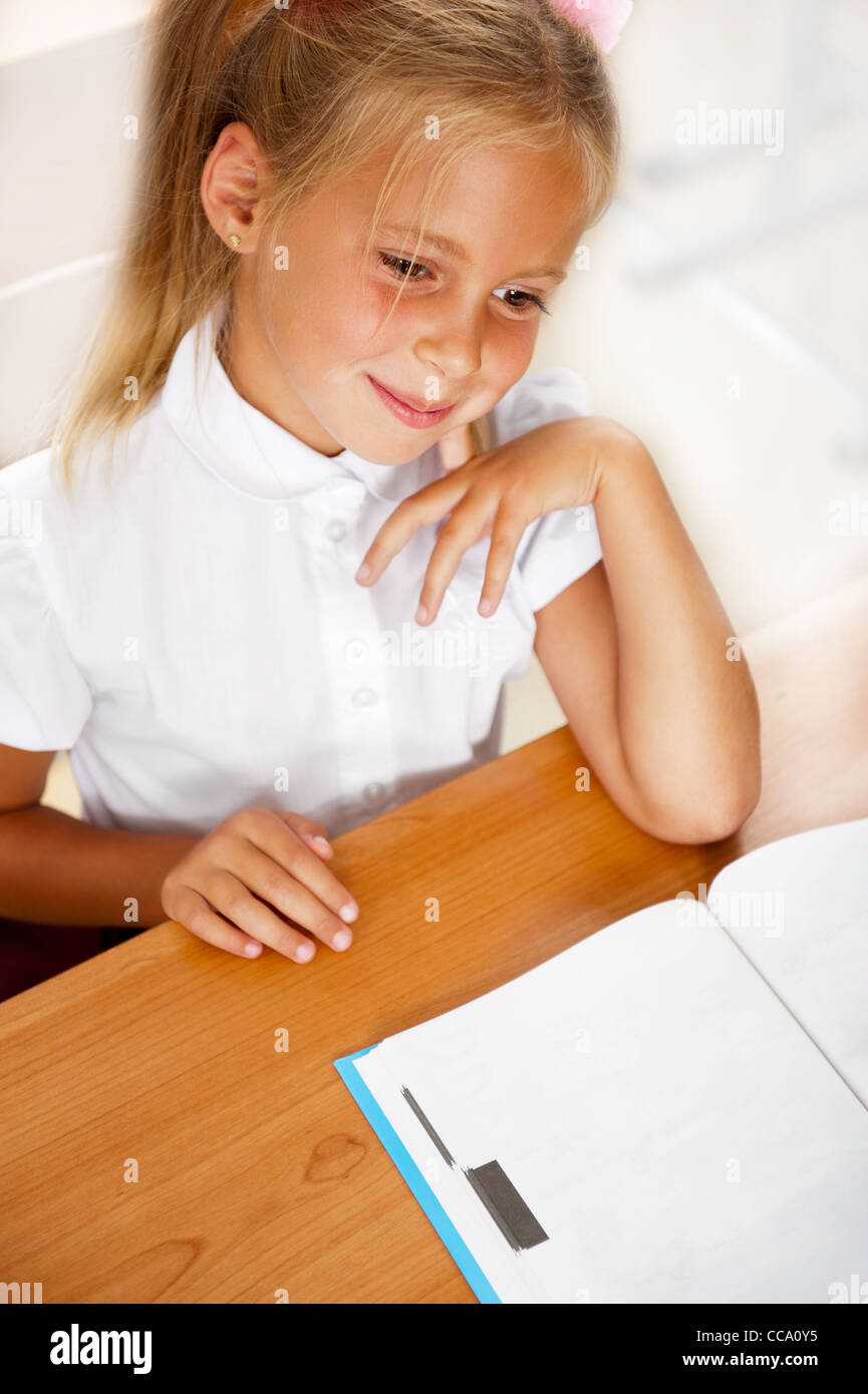 Image of smart child reading interesting book in classroom. Vertical ...