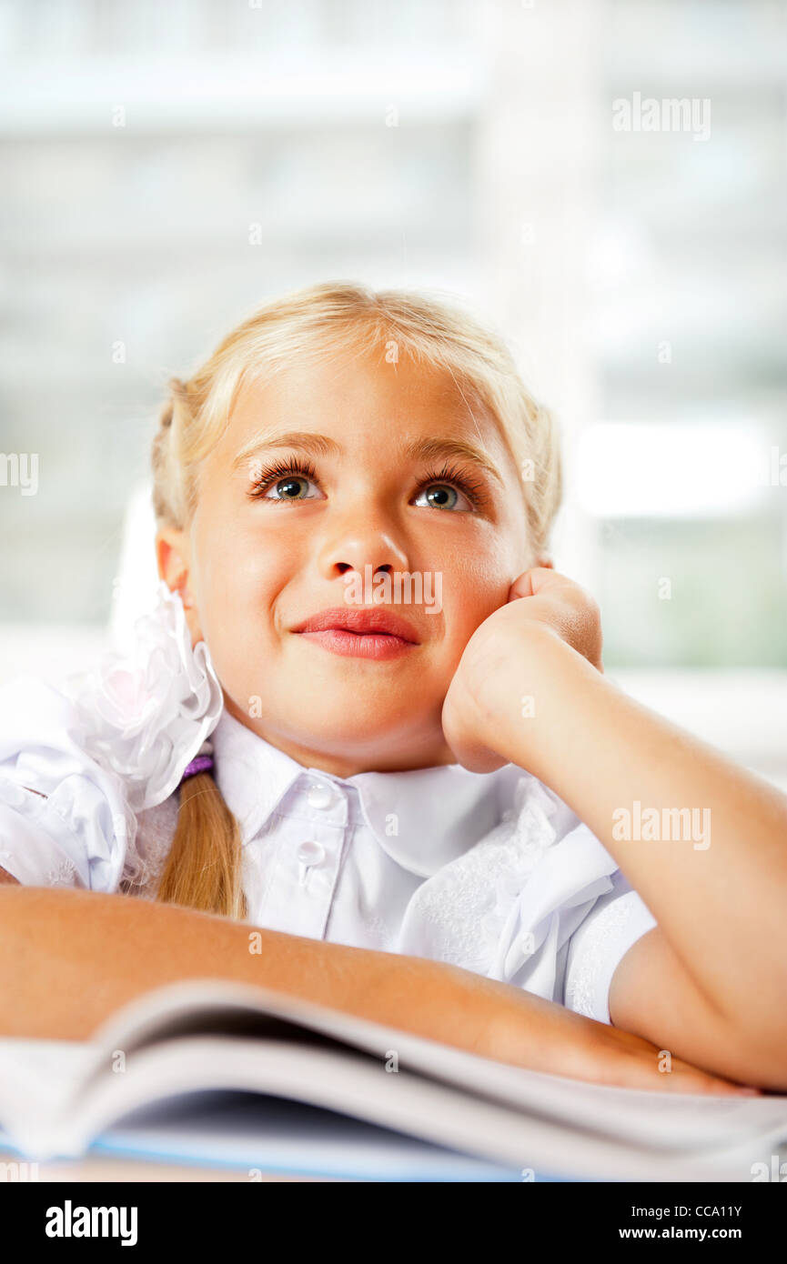 Image of smart child reading interesting book in classroom. Vertical ...