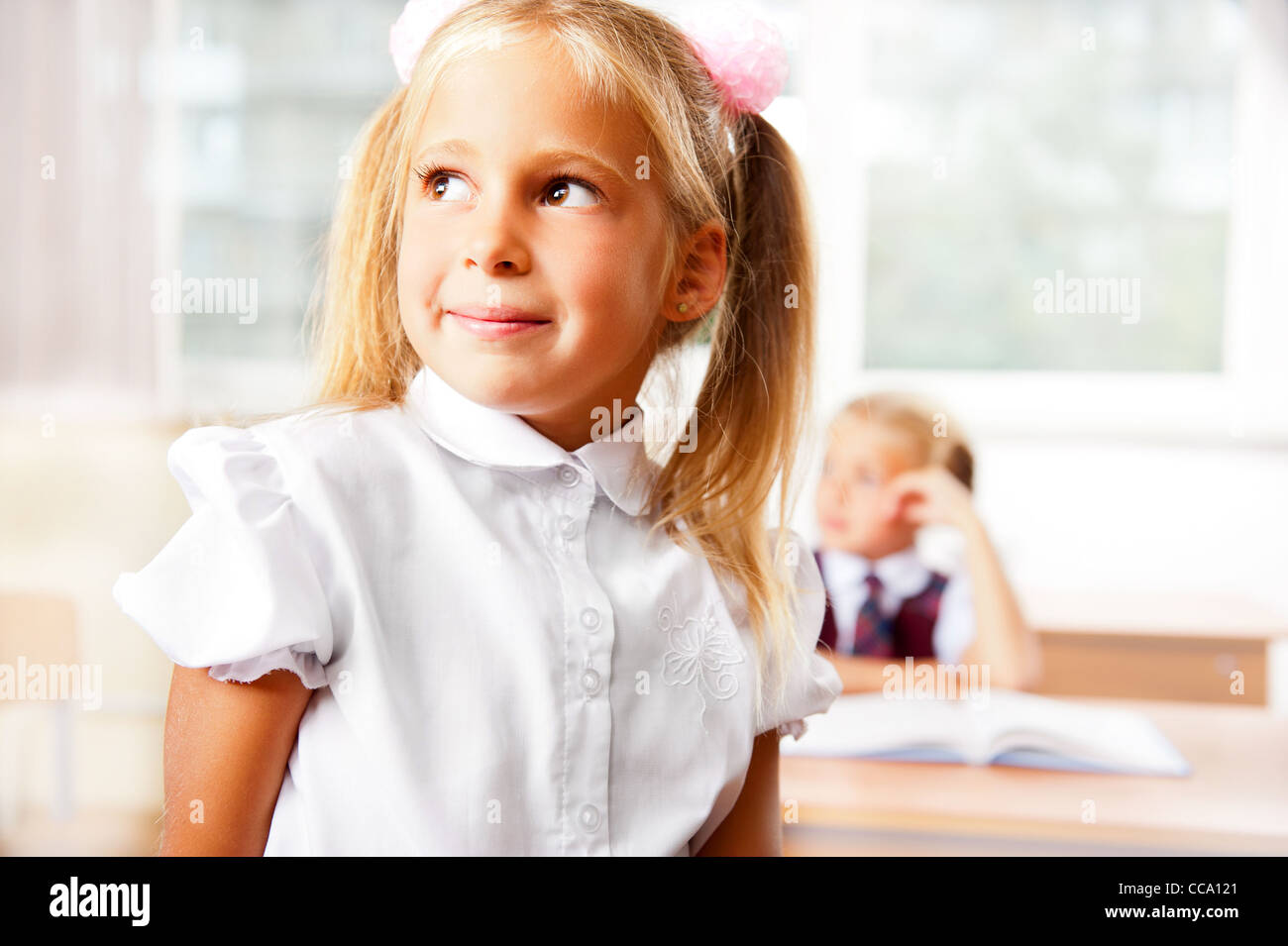 Portrait of a schoolgirl being in a classroom at school with her ...