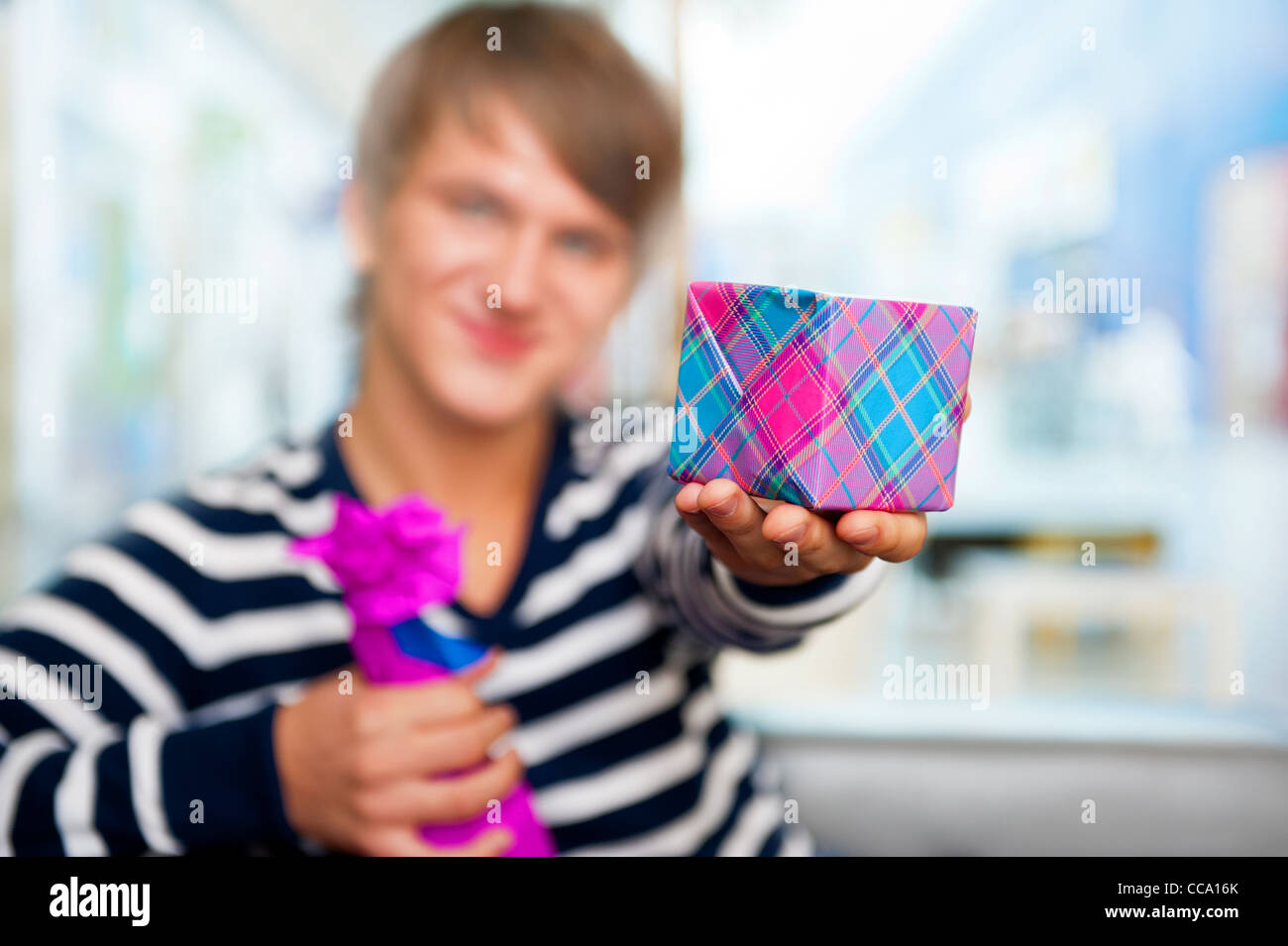 Portrait of young man inside shopping mall standing relaxed and holding ...