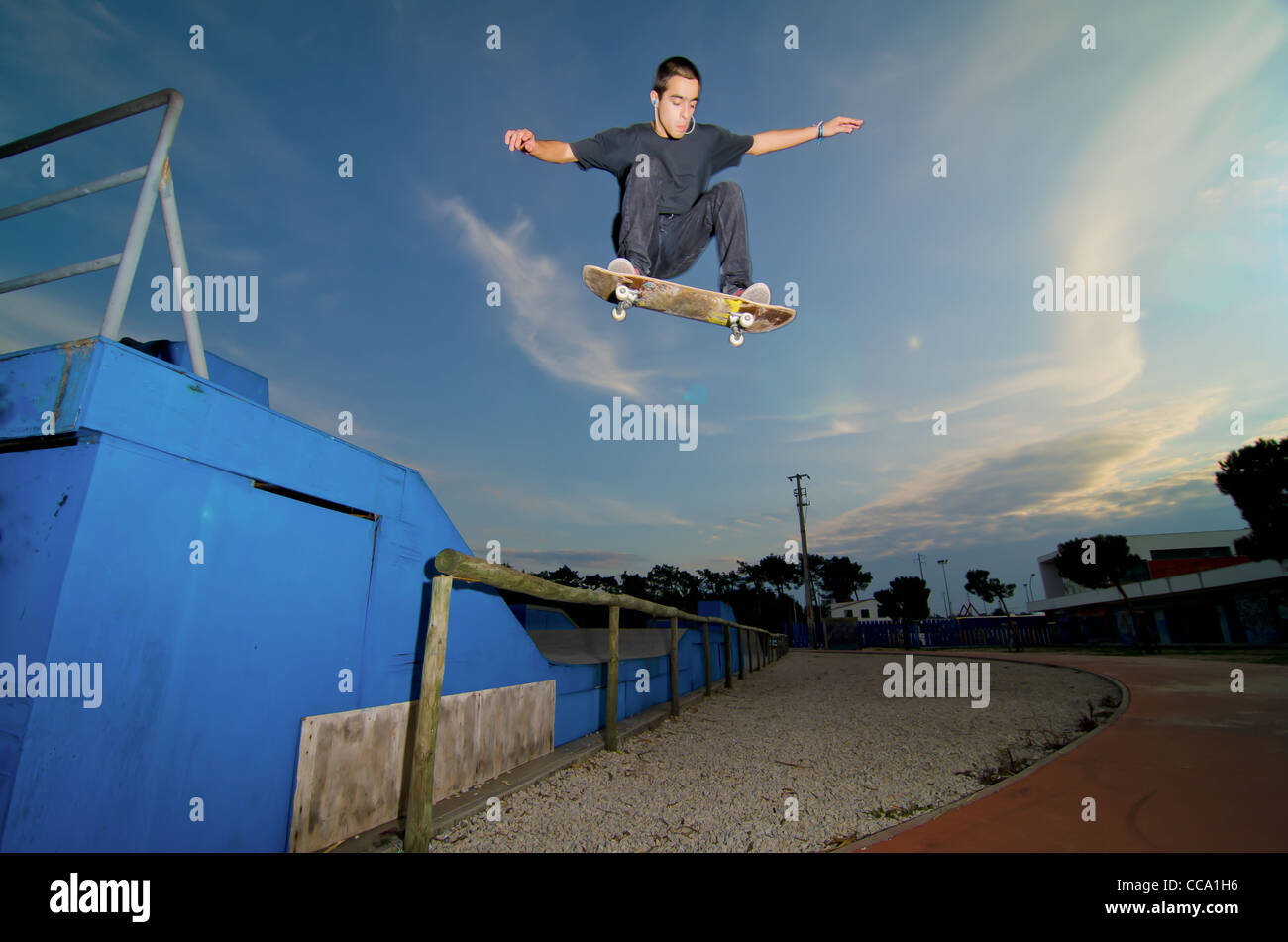 Skateboarder flying over a ramp on sunset at the local skatepark Stock ...