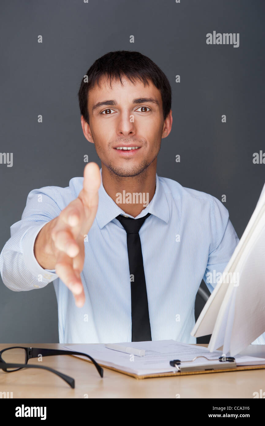 Portrait of an adult business man sitting in the office and holding ...