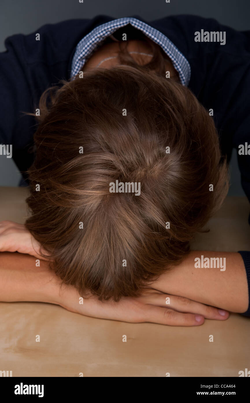 Portrait of tired man laying face down on table at his office Stock ...