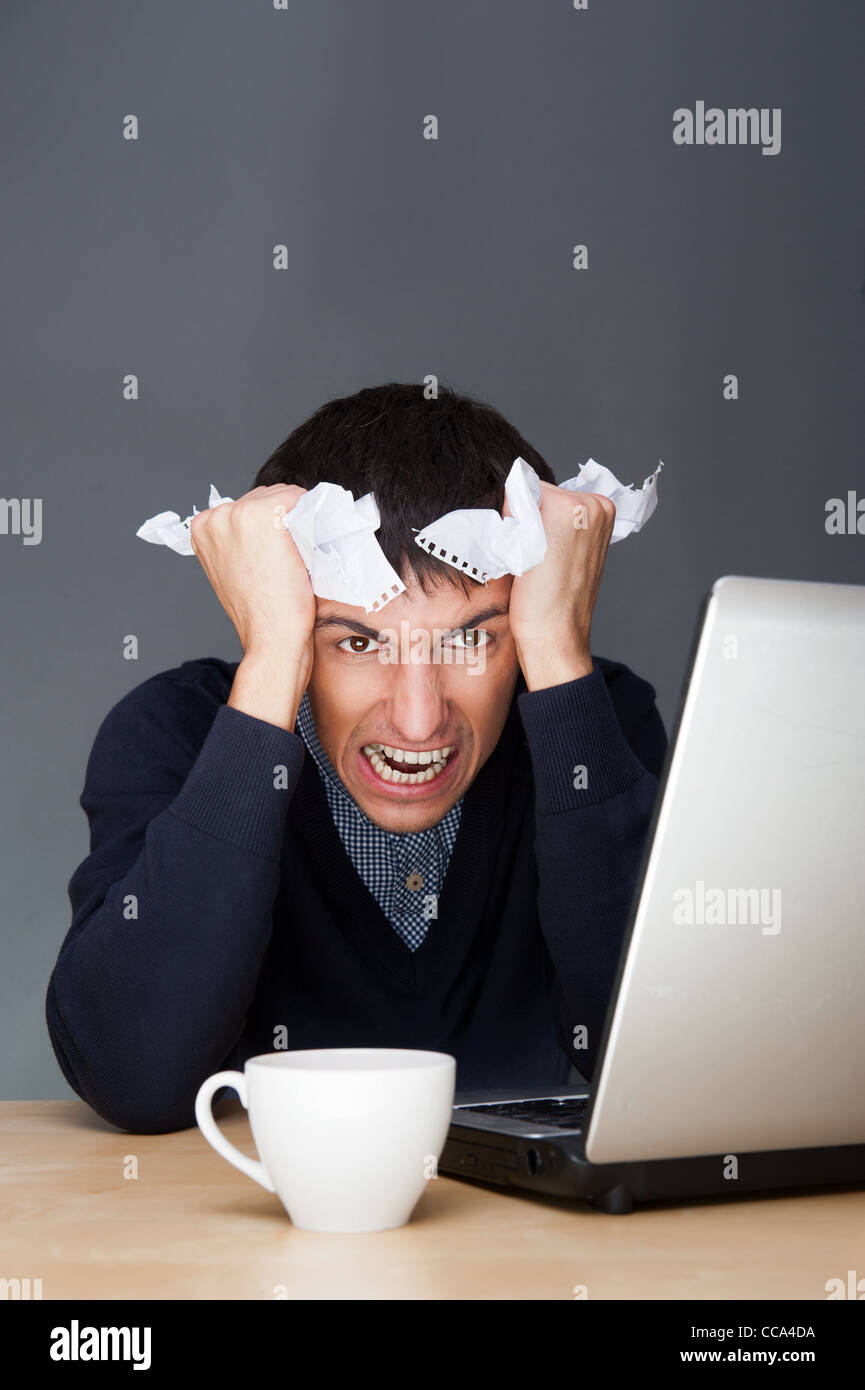 Closeup of a young angry business man having a stress. Headache ...