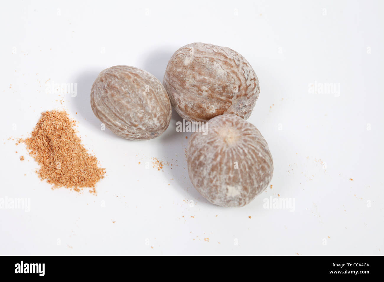 Three nutmegs and grounded Stock Photo - Alamy