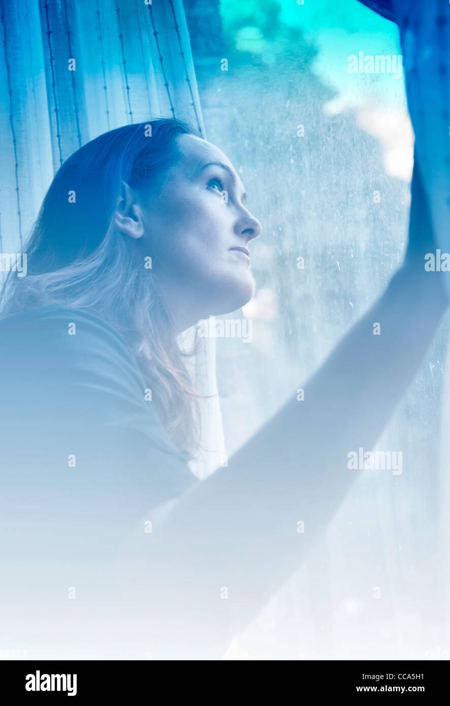 Woman looking up out of window Stock Photo - Alamy