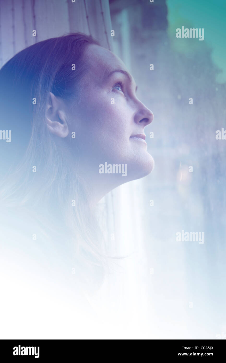 Woman looking up out of window Stock Photo - Alamy