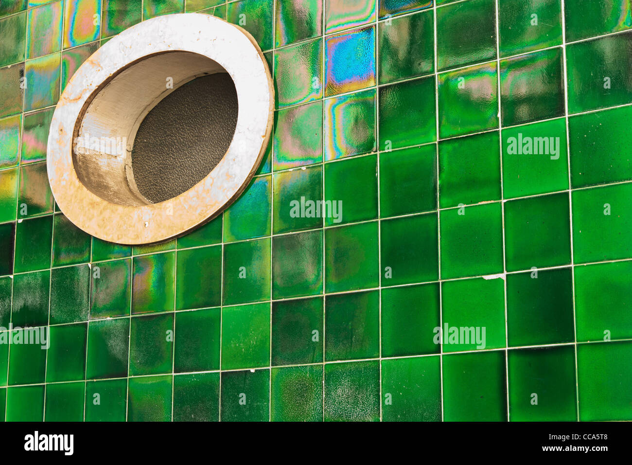 Oval window in wall of green old tiles Stock Photo - Alamy